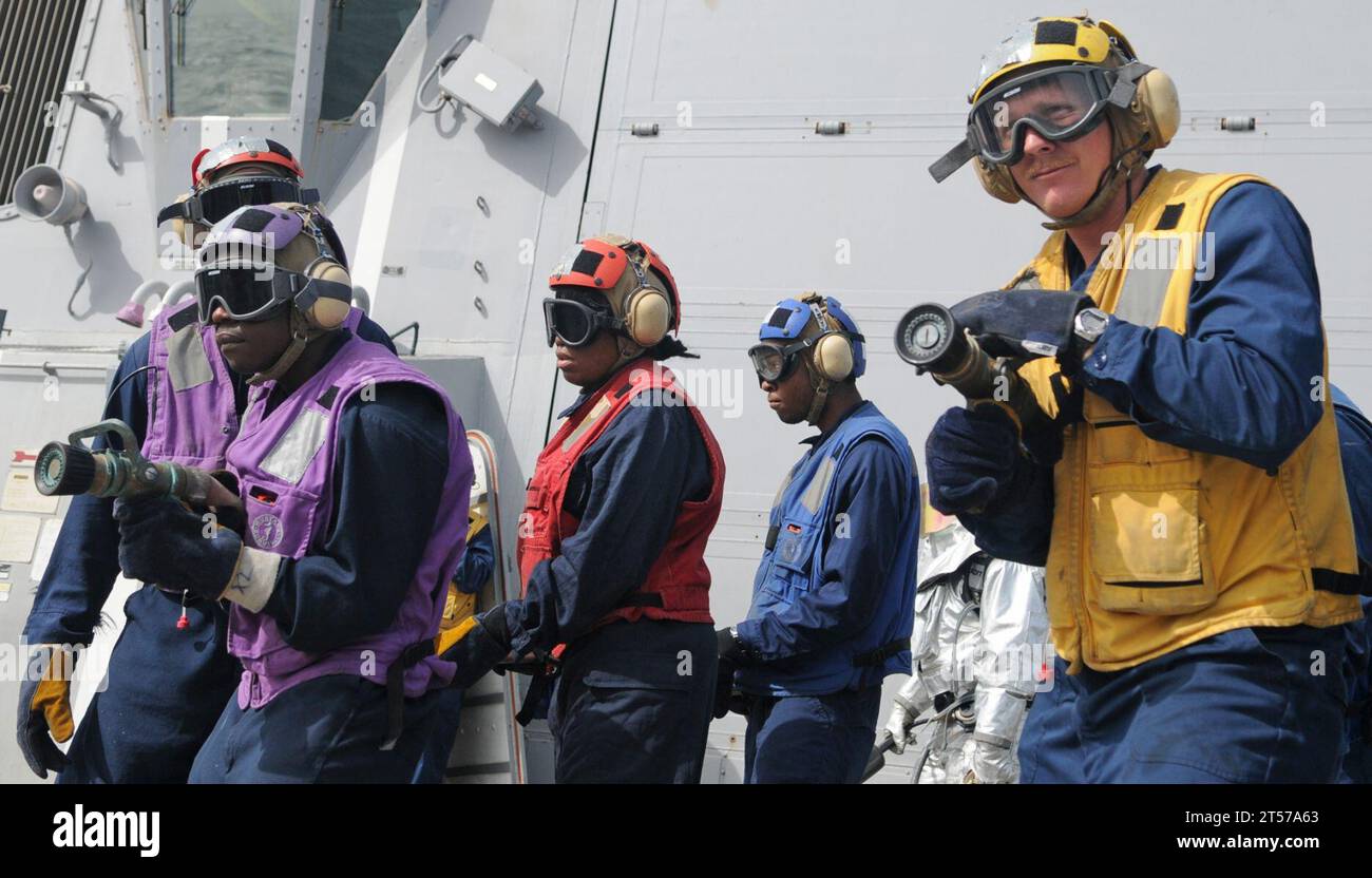 US Navy Sailors simulate fighting a fire during a flight deck recovery ...