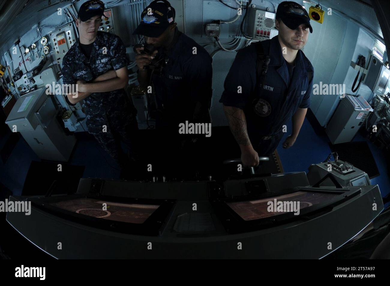 US Navy Sailors stand lee helmsman and helmsman in the bridge aboard ...