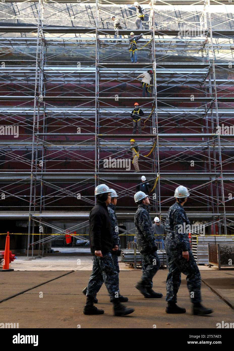 US Navy Sailors walk alongside the aircraft carrier USS Ronald Reagan ...