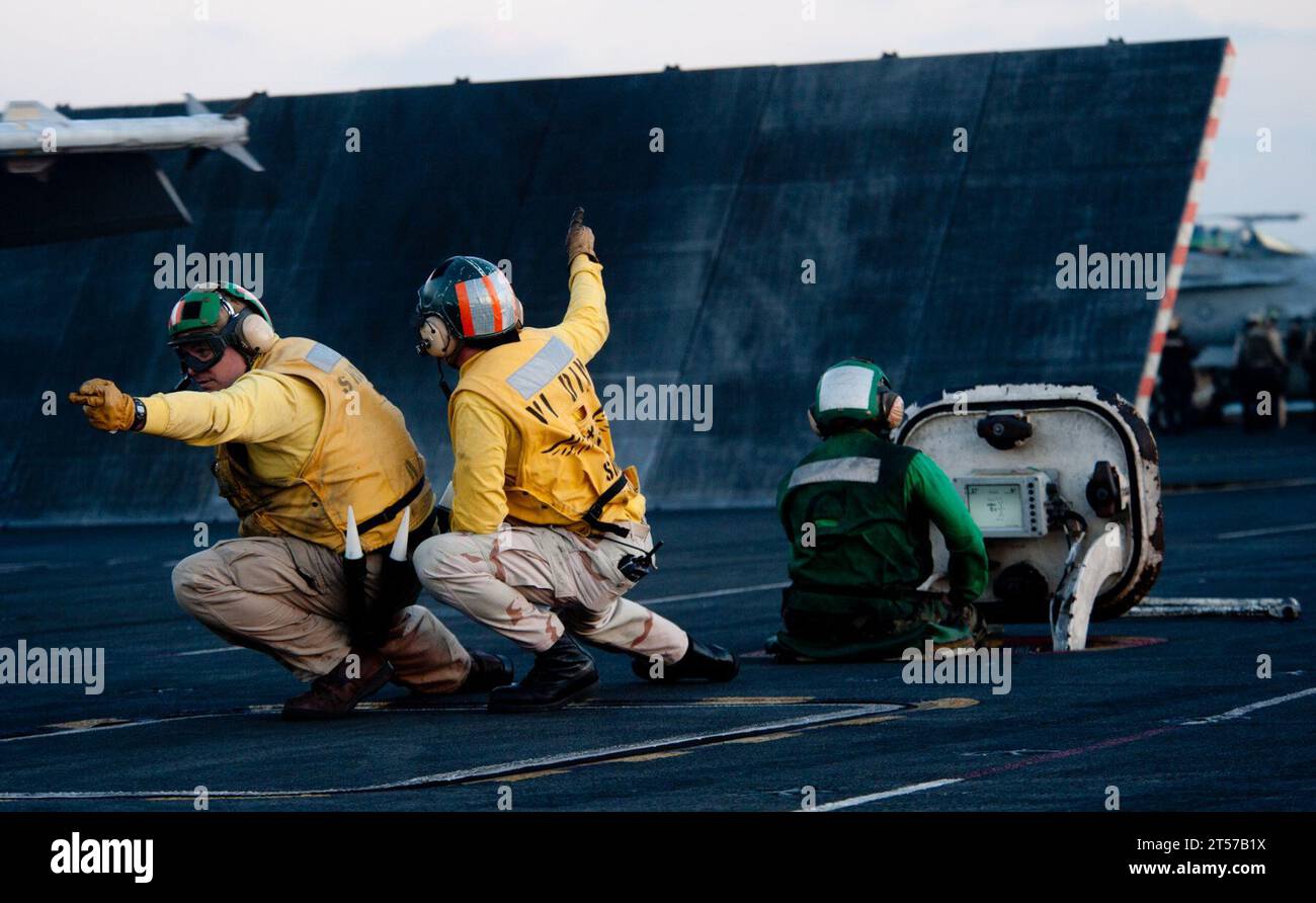 US Navy Shooters signal for the launching of an aircraft off the flight ...