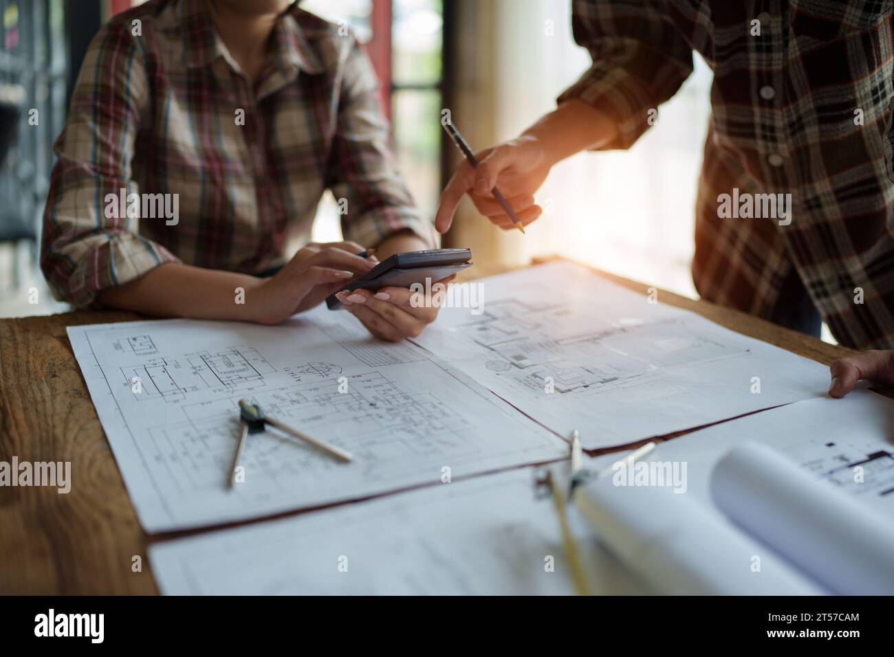 multi ethnic engineer brainstorming and measuring for cost estimating ...