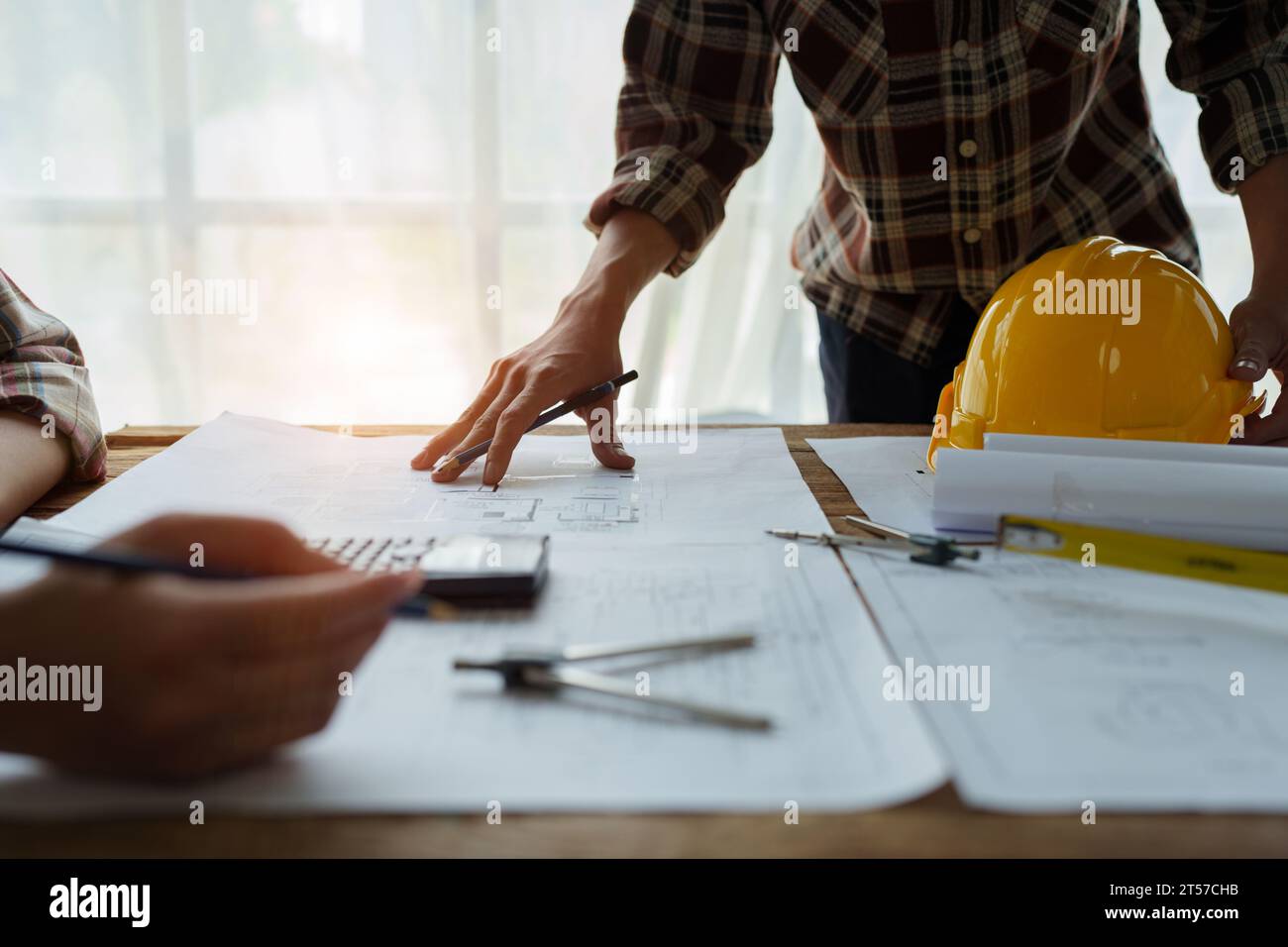 multi ethnic engineer brainstorming and measuring for cost estimating ...