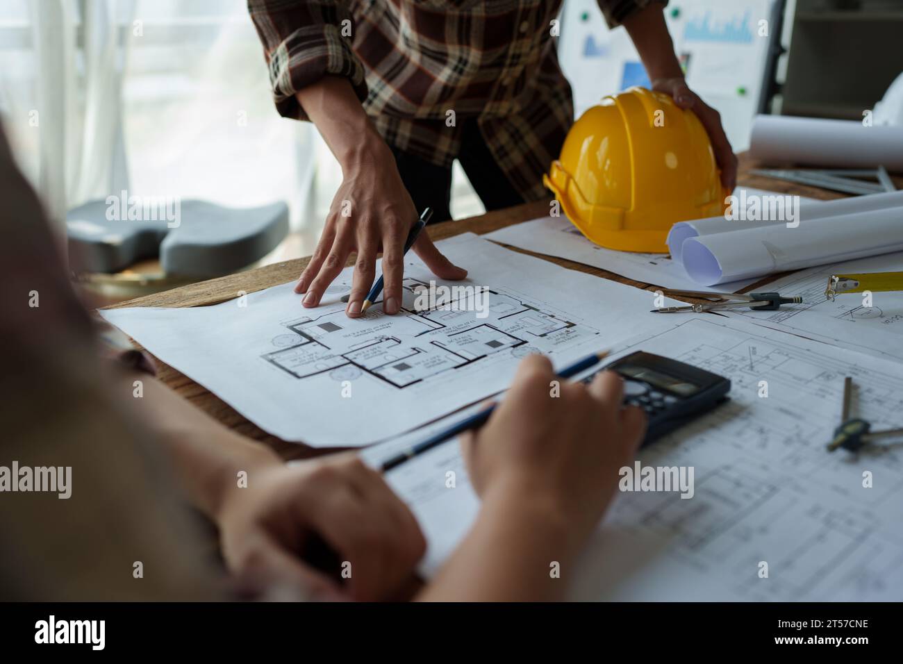 multi ethnic engineer brainstorming and measuring for cost estimating ...