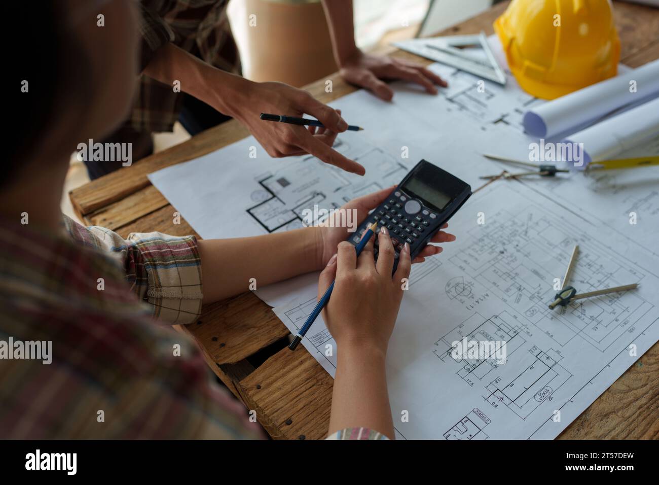 multi ethnic engineer brainstorming and measuring for cost estimating ...