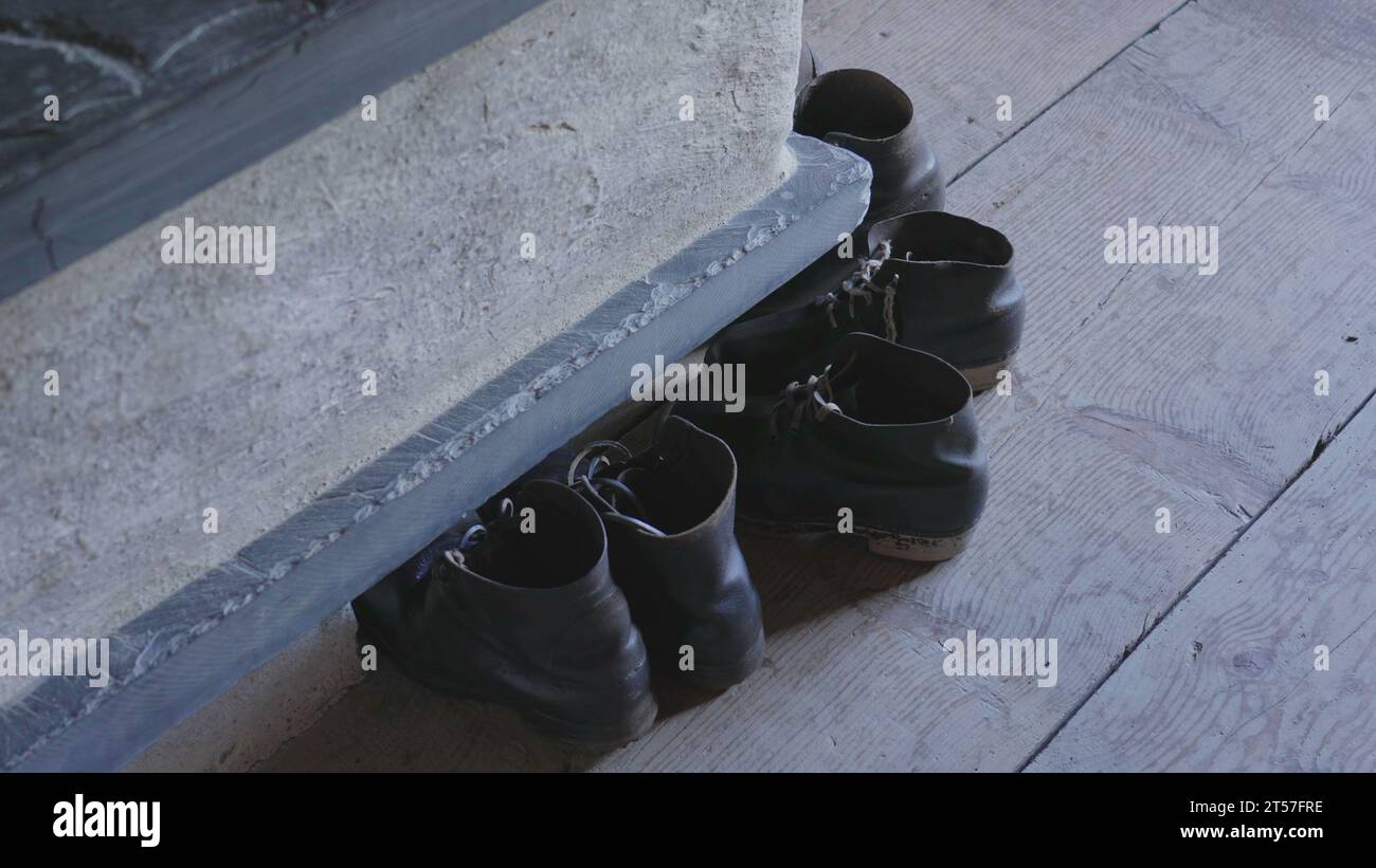 Ancient rural shoes on display at wooden floor, rural ambience. Rustic ...
