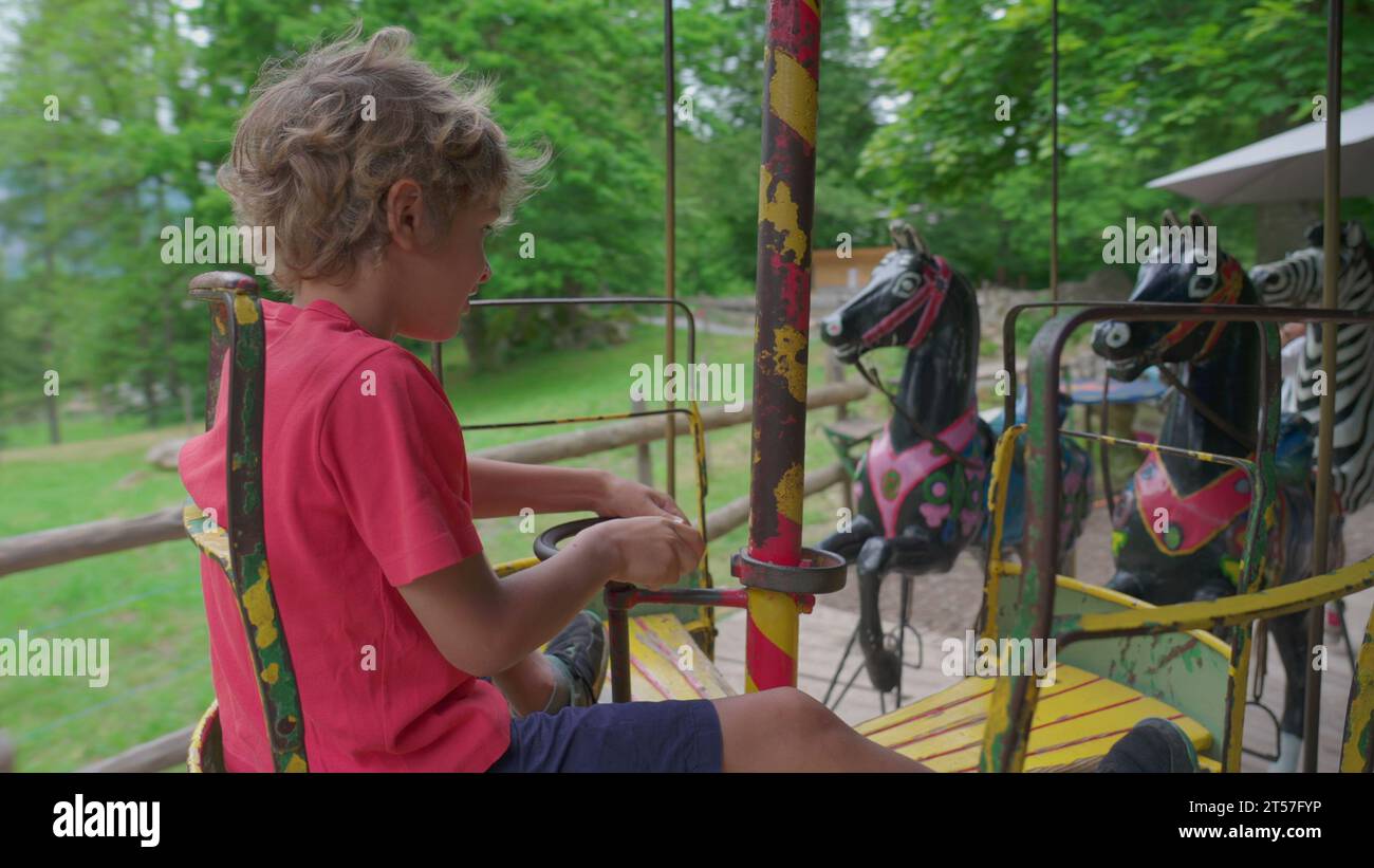 Child spinning inside carousel merry-go-round, Little boy turning ...
