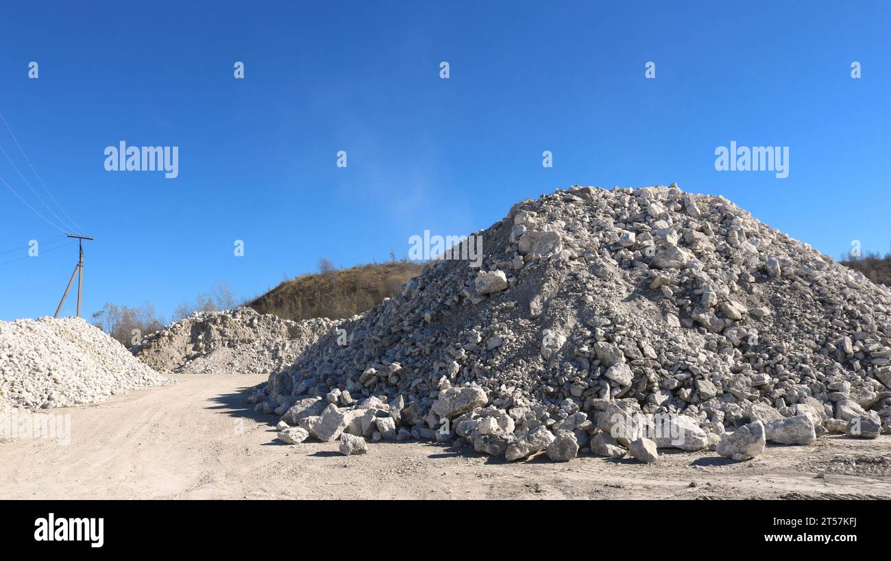a pile of light stones in a desert landscape at a limestone mining site ...