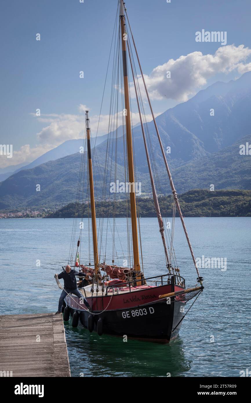 Old style sailing yacht prepares to dock alongside a jetty on Lake Como ...