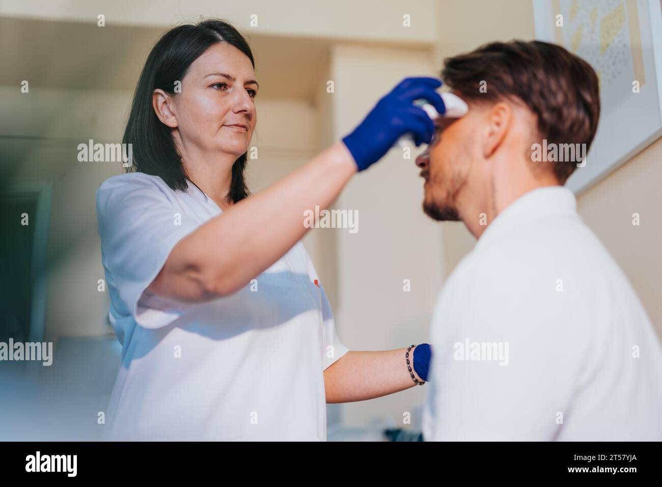 Female doctor checking temperature of patient Stock Photo - Alamy