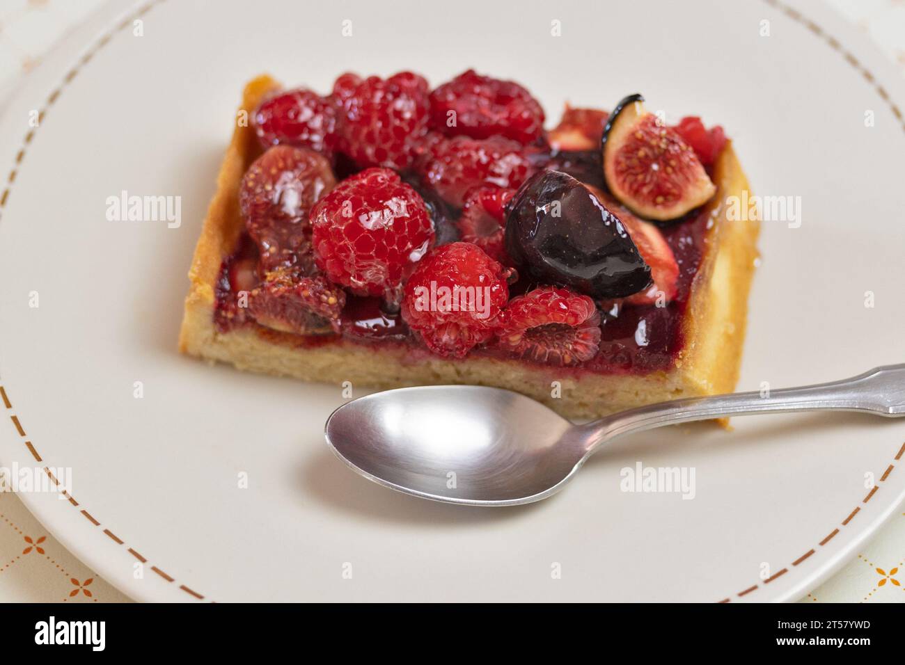 slice of red fruit tart on a plate, close-up Stock Photo - Alamy