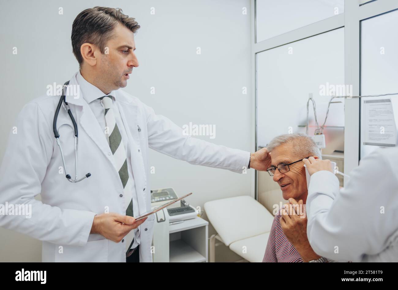 Doctor washing and cleaning elderly patients ears. Washing ears concept ...