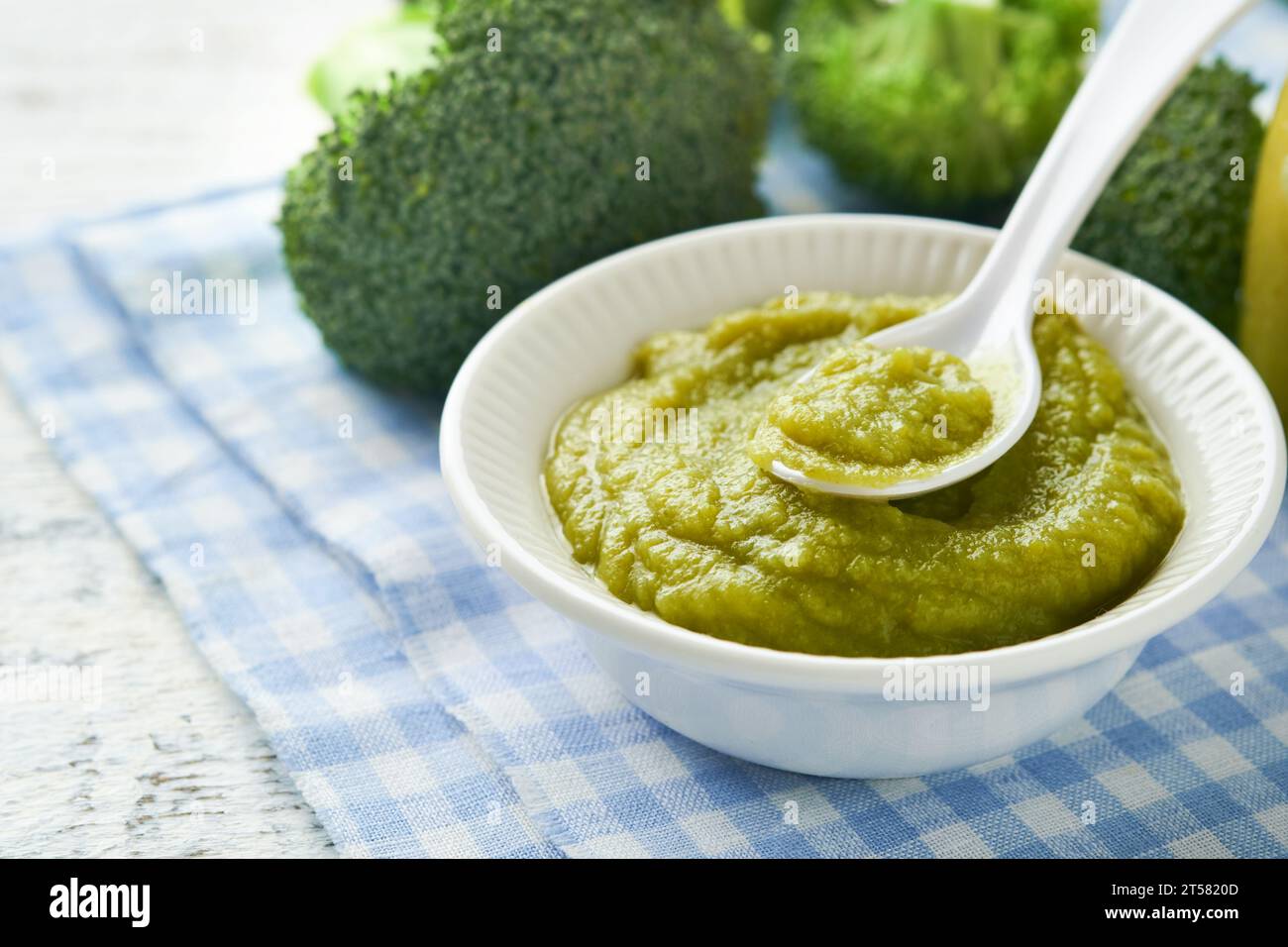 Green broccoli baby food in white bowl and jar on table. Green baby ...