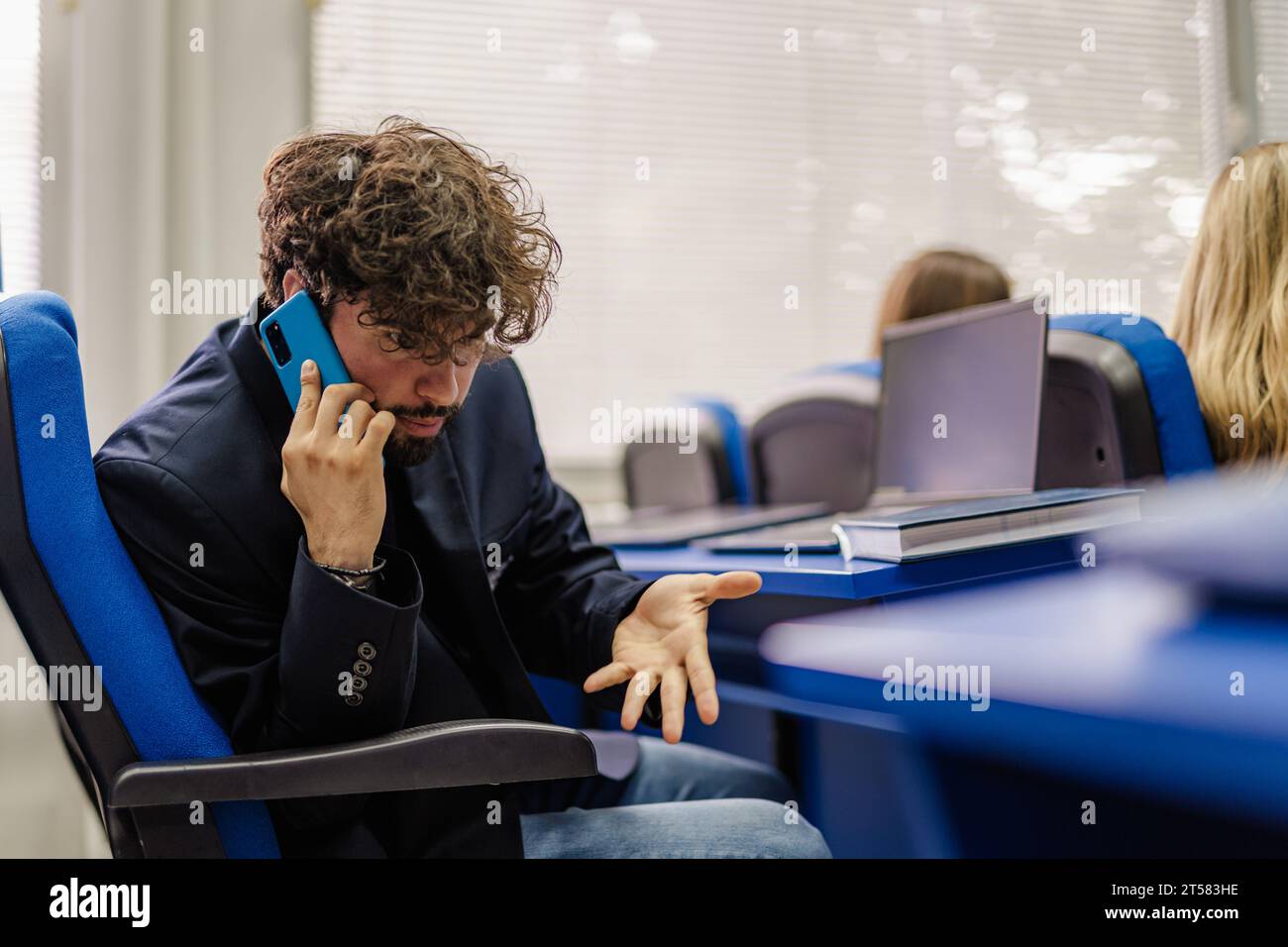 Student talking and arguing on his phone during class Stock Photo - Alamy