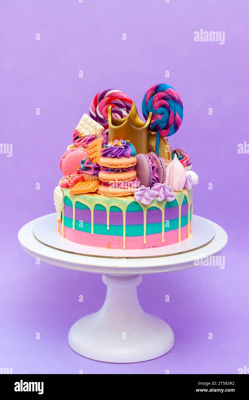 Bright and colorful cake with golden crown, lollipops, swirls ...