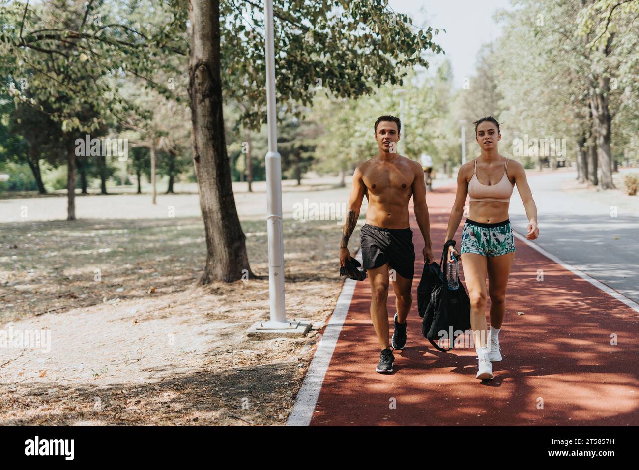 Athletes with fit bodies enjoy a sunny day in the park, discussing the ...