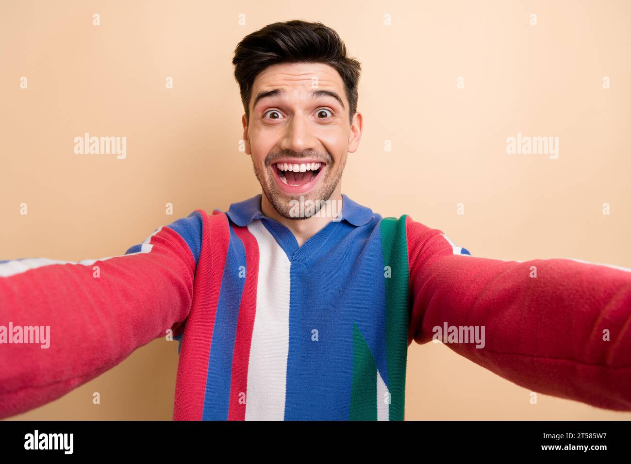 Selfie cadre of positive funny young vlogger man holding camera ...