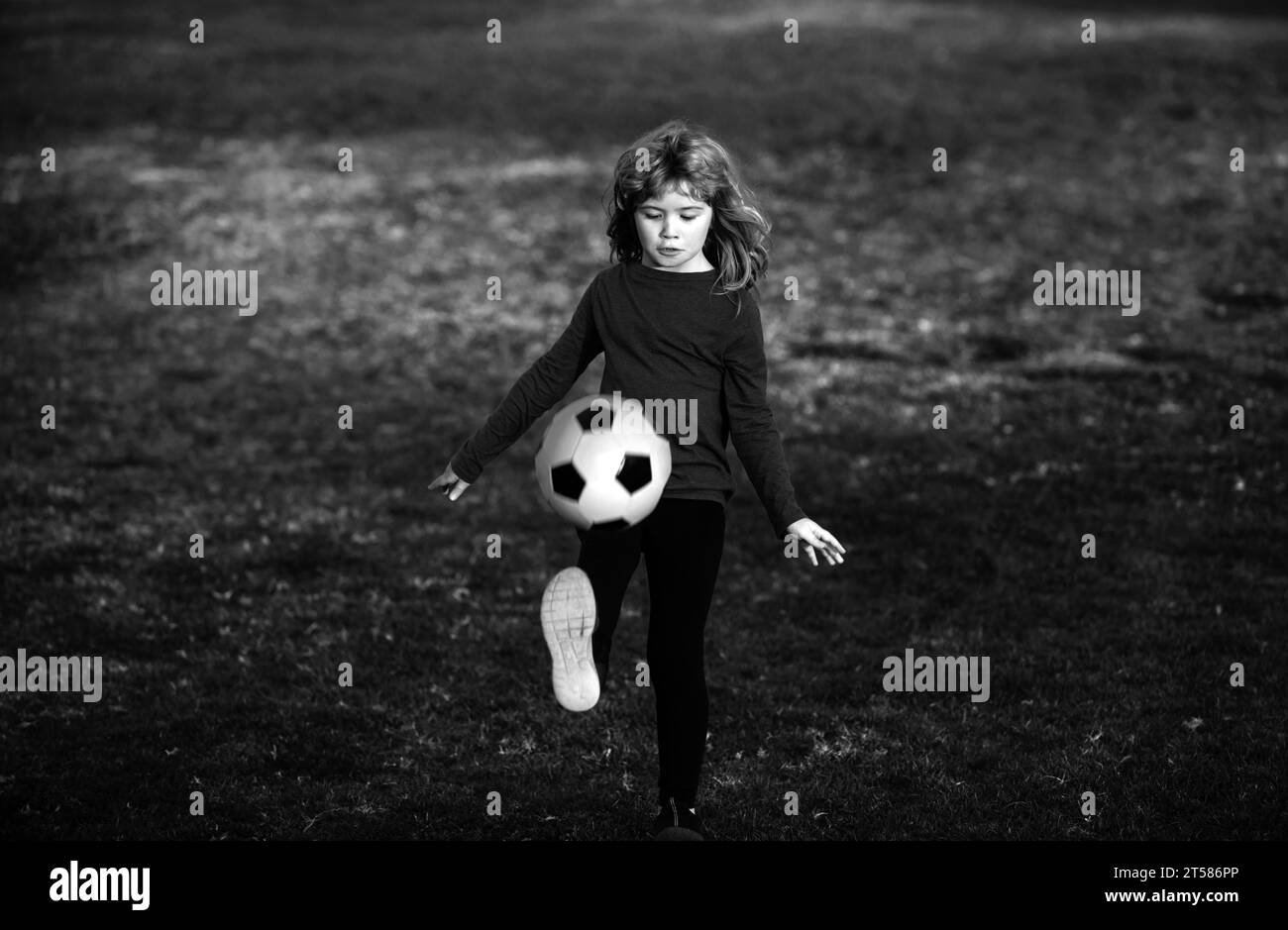 Boy child playing football on football field. Kid playing soccer ...