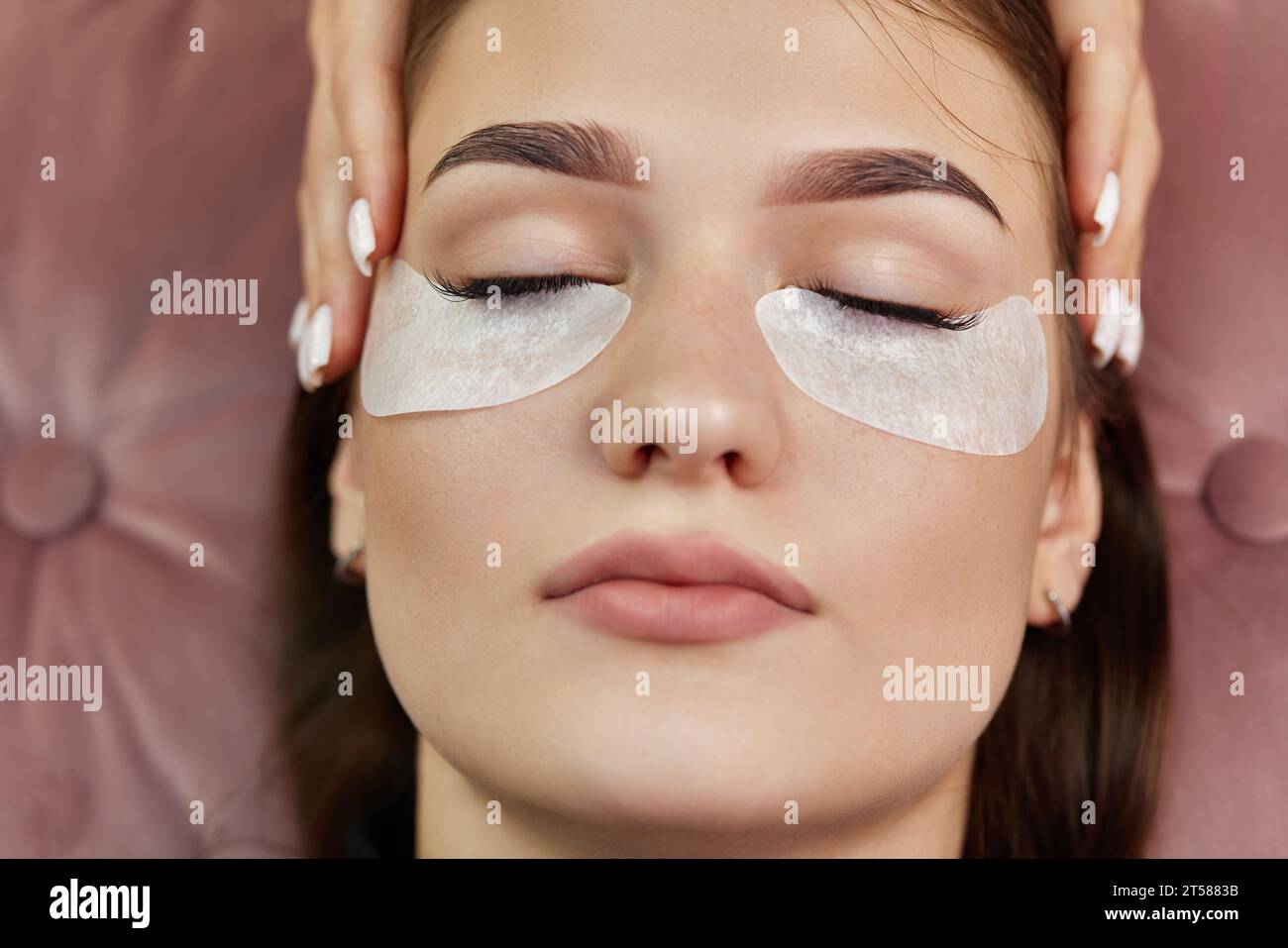 cosmetologist preparing glue cotton strip under eye. Eyelash extension ...