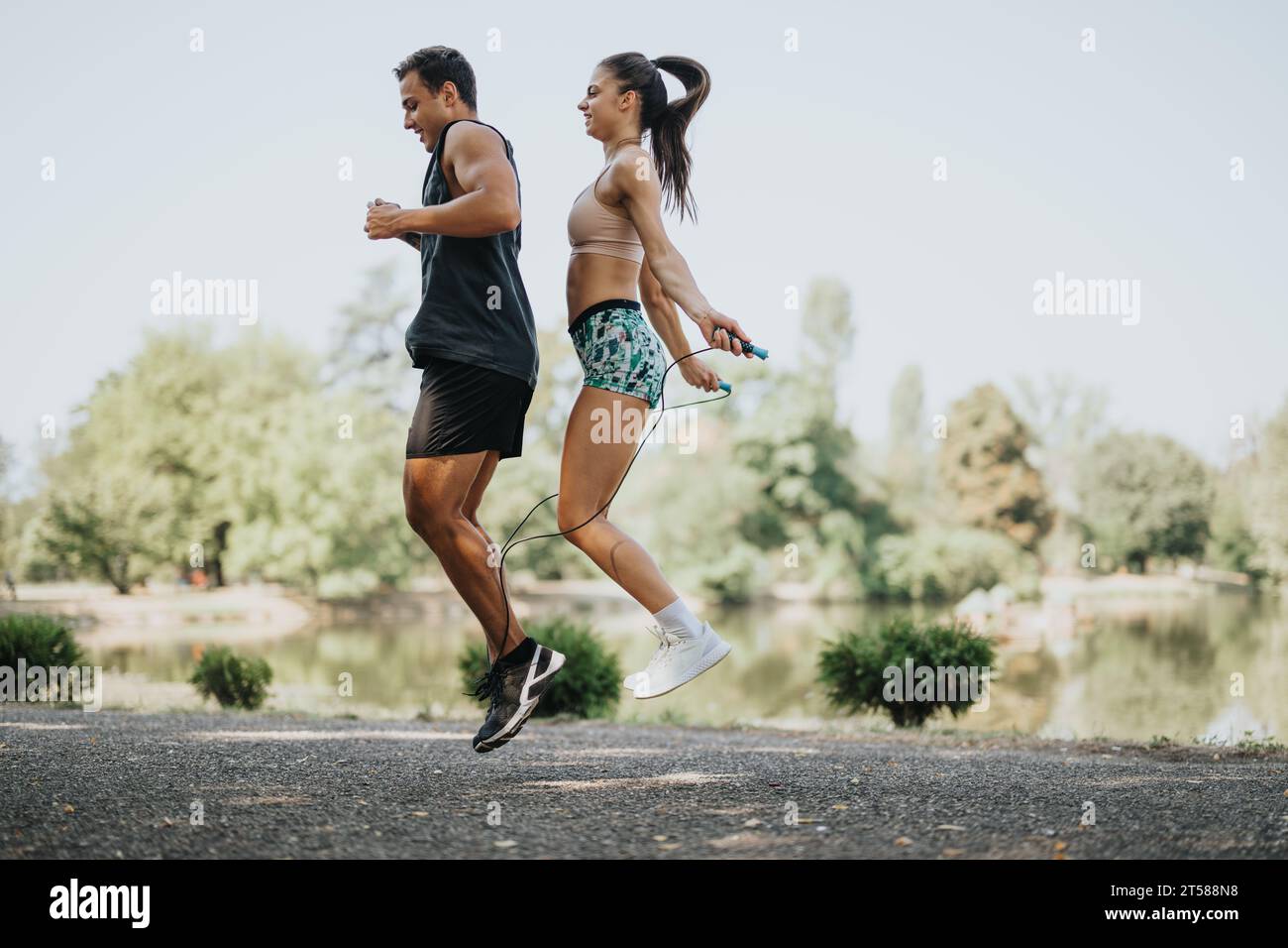 A happy Caucasian couple exercises together in a sunny park, engaging ...