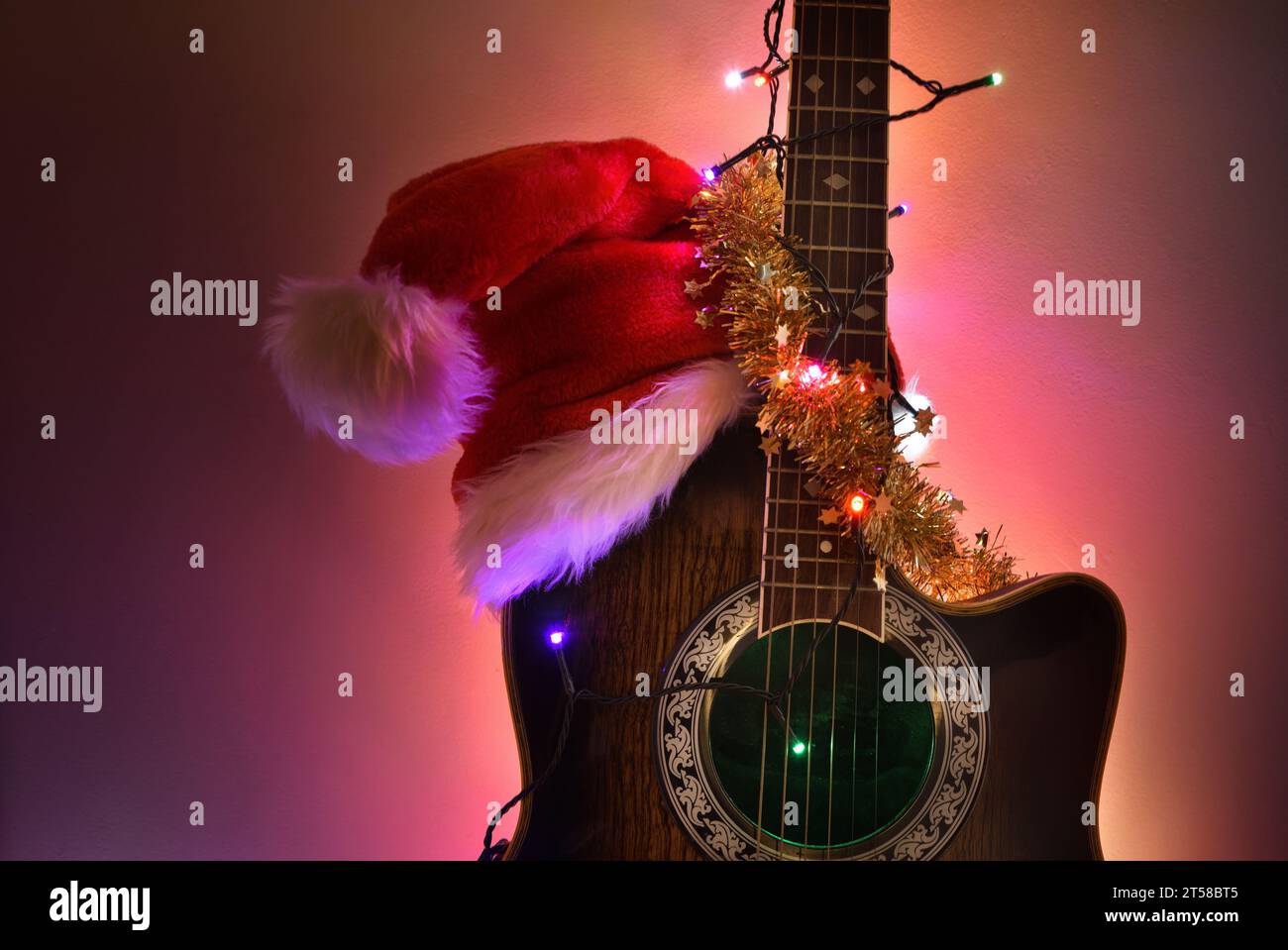 Acoustic guitar body with Santa hat and Christmas lights and tinsel ...
