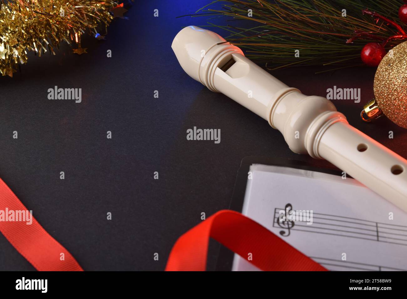 Traditional plastic recorder on black table with Christmas decoration ...