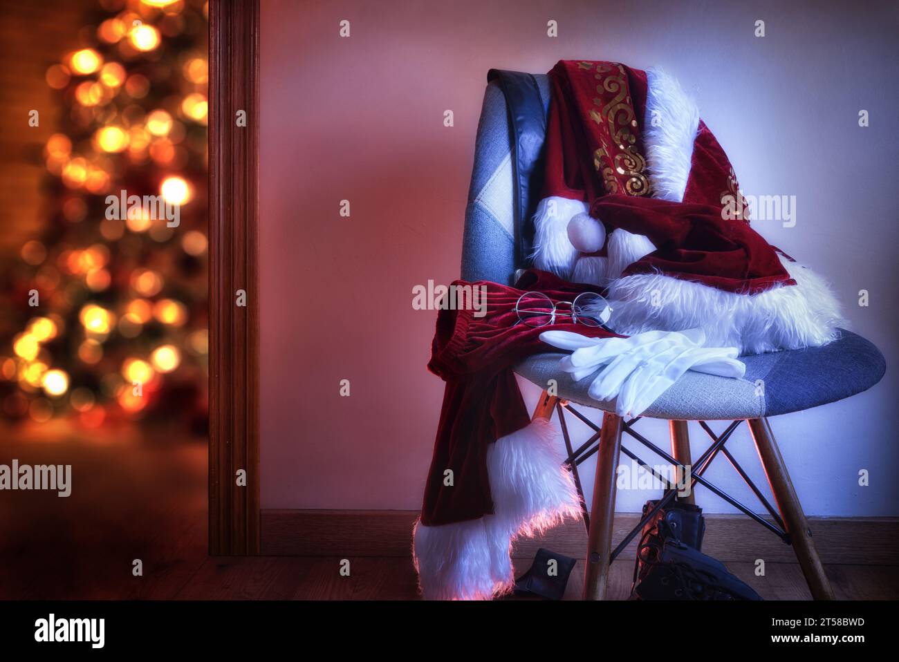Santa Claus clothes on a chair after distributing gifts in a room with ...