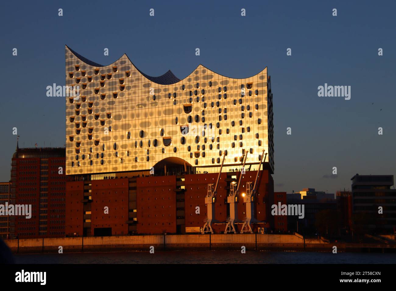 Hamburger Hafen: Die Glasfassade der Elbphilharmonie reflektiert das Licht der tiefstehenden ...