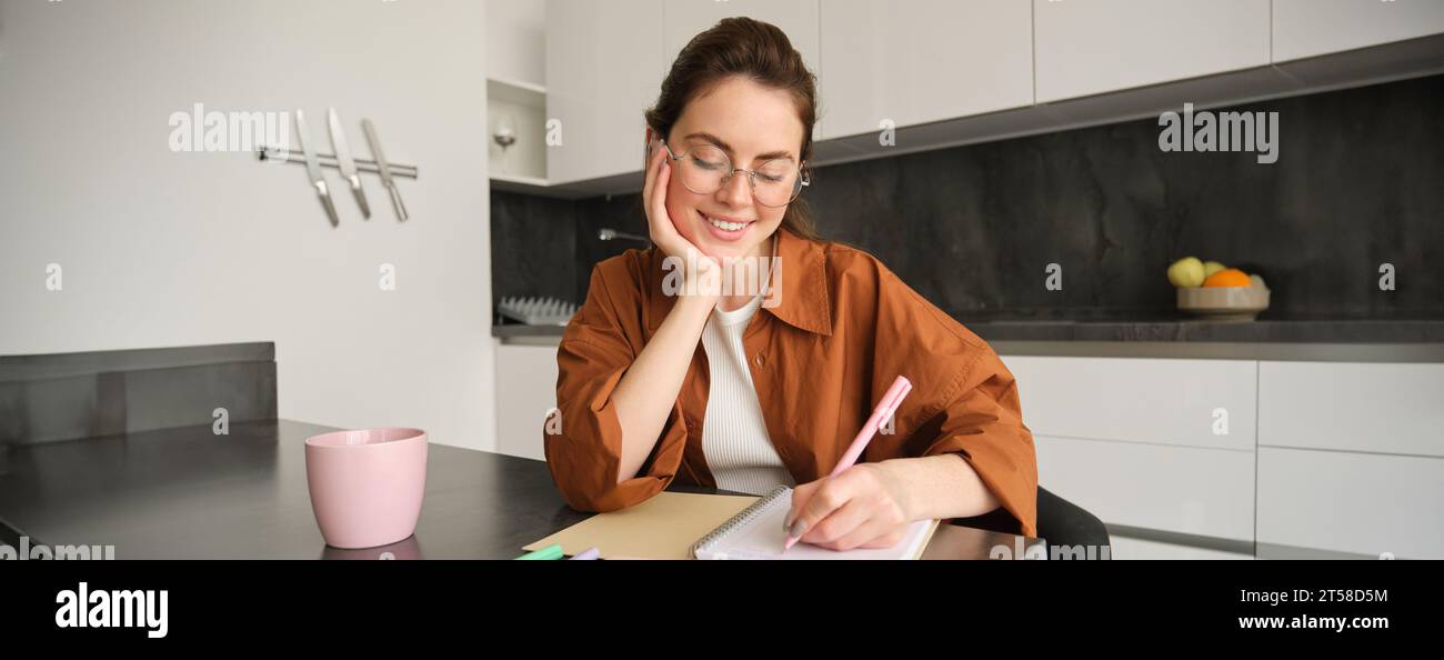 Beautiful young woman, self-employed girl working from home, sitting in ...