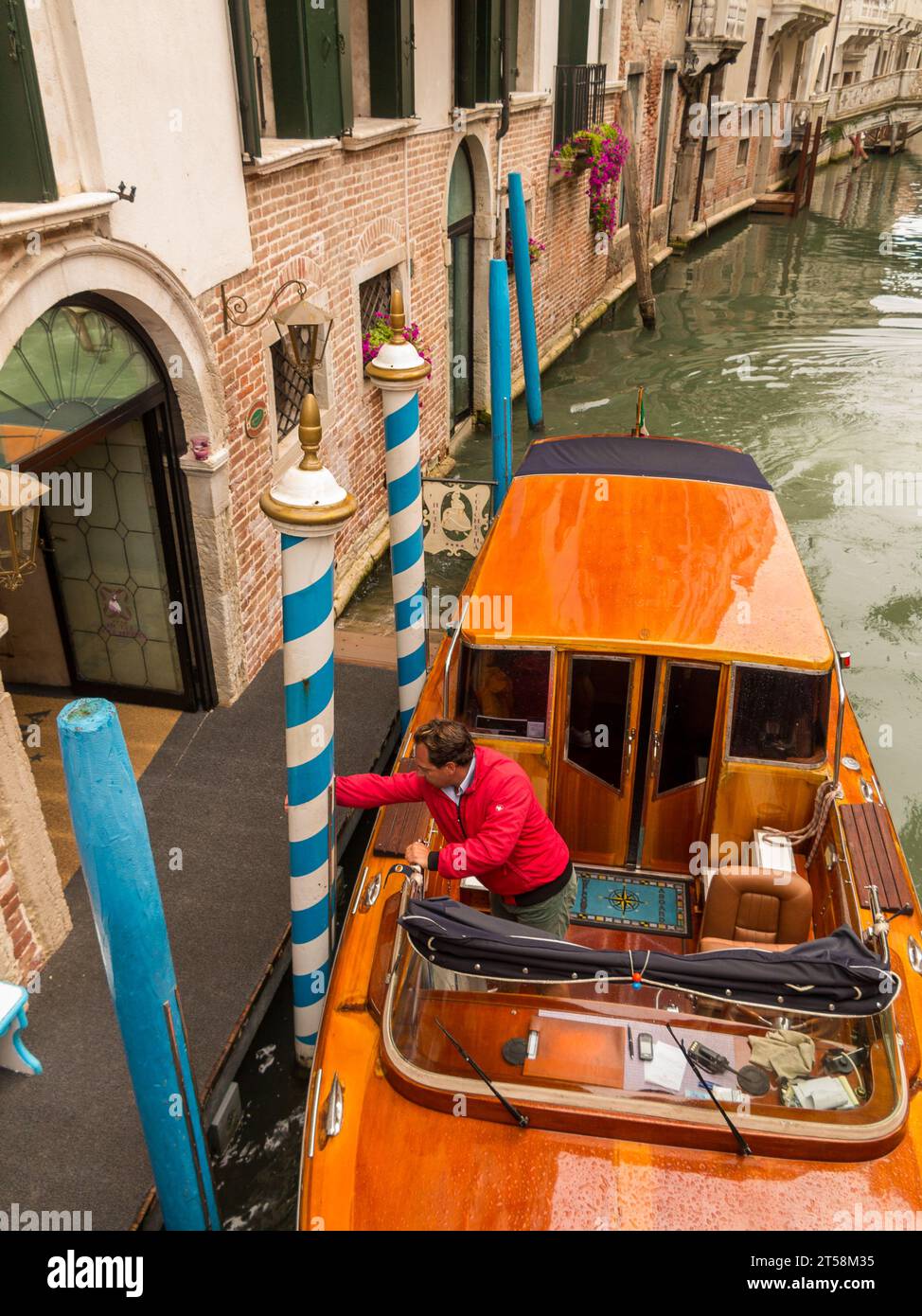 A water taxi driver, also called motoscafo, mooring his boat at a dock ...