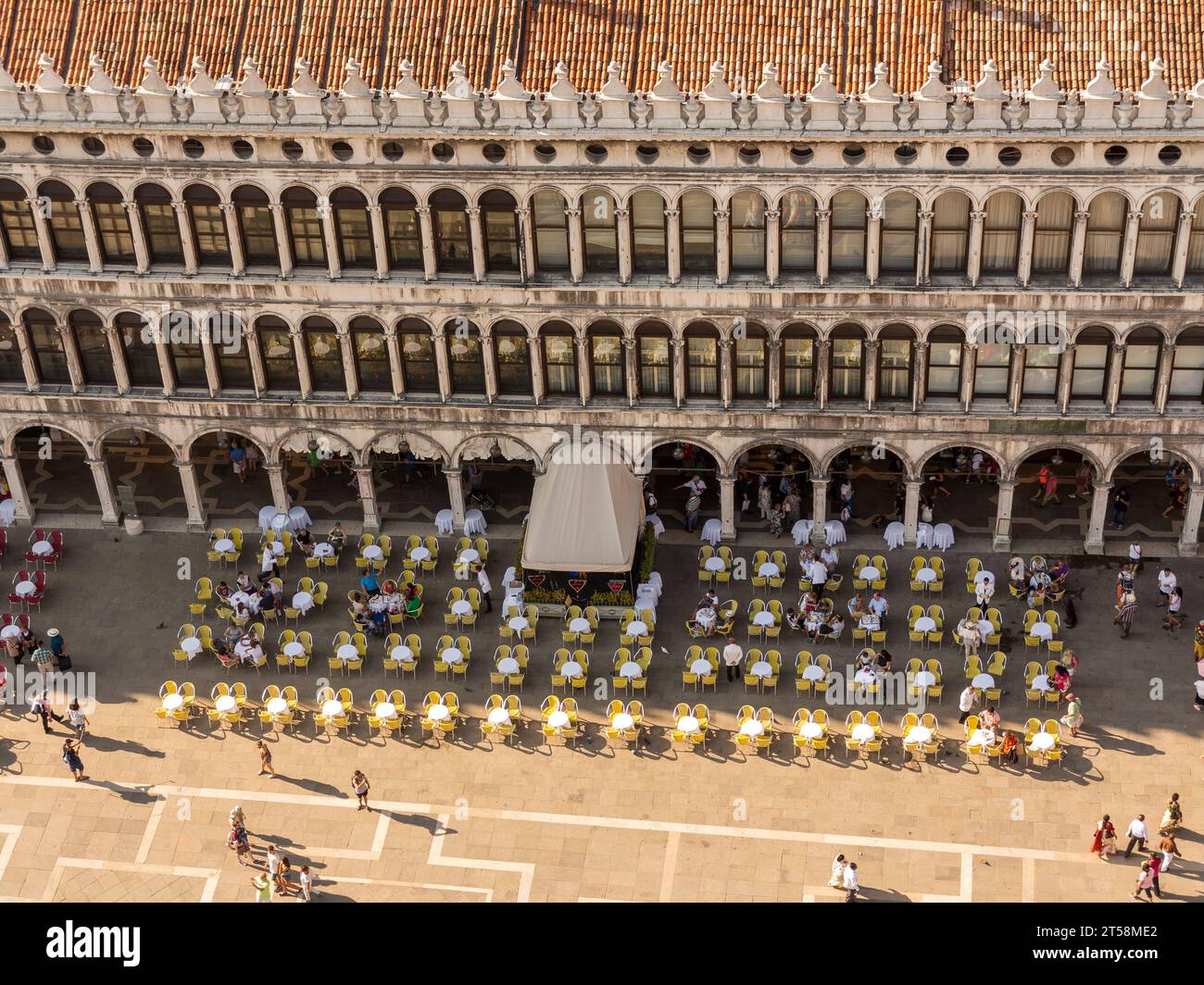 Terrace of a café on St. Mark's Square where tourists stroll, bird's ...