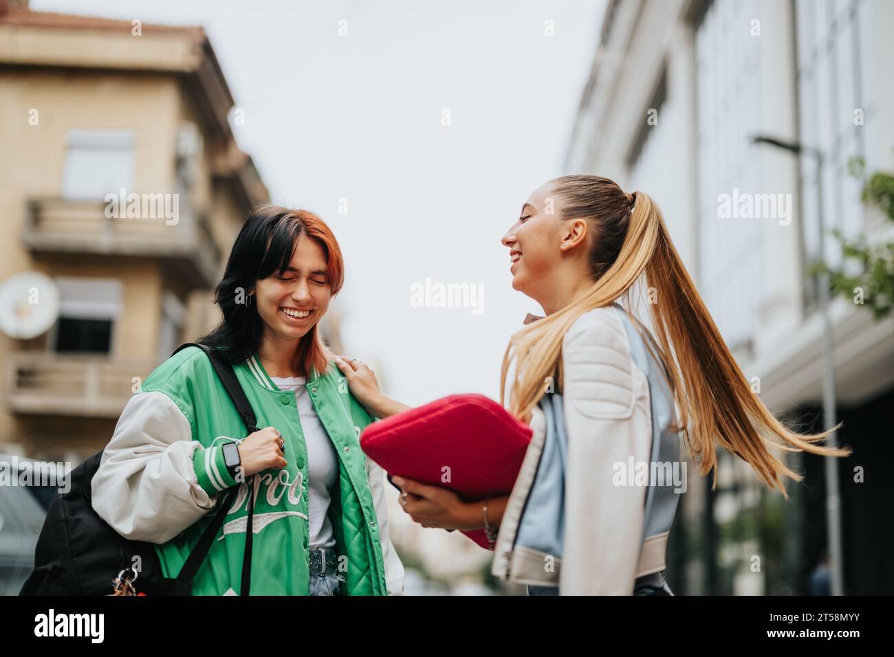 Two Young Women Enjoying a Study Session Outdoors, Helping Each Other ...