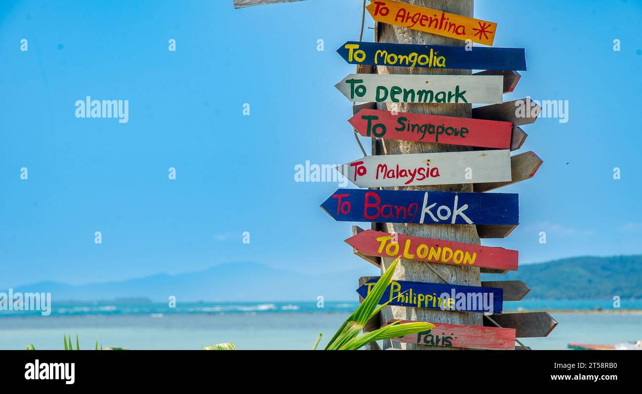 Wooden arrow-shaped and coloured signposts showing directions to many ...