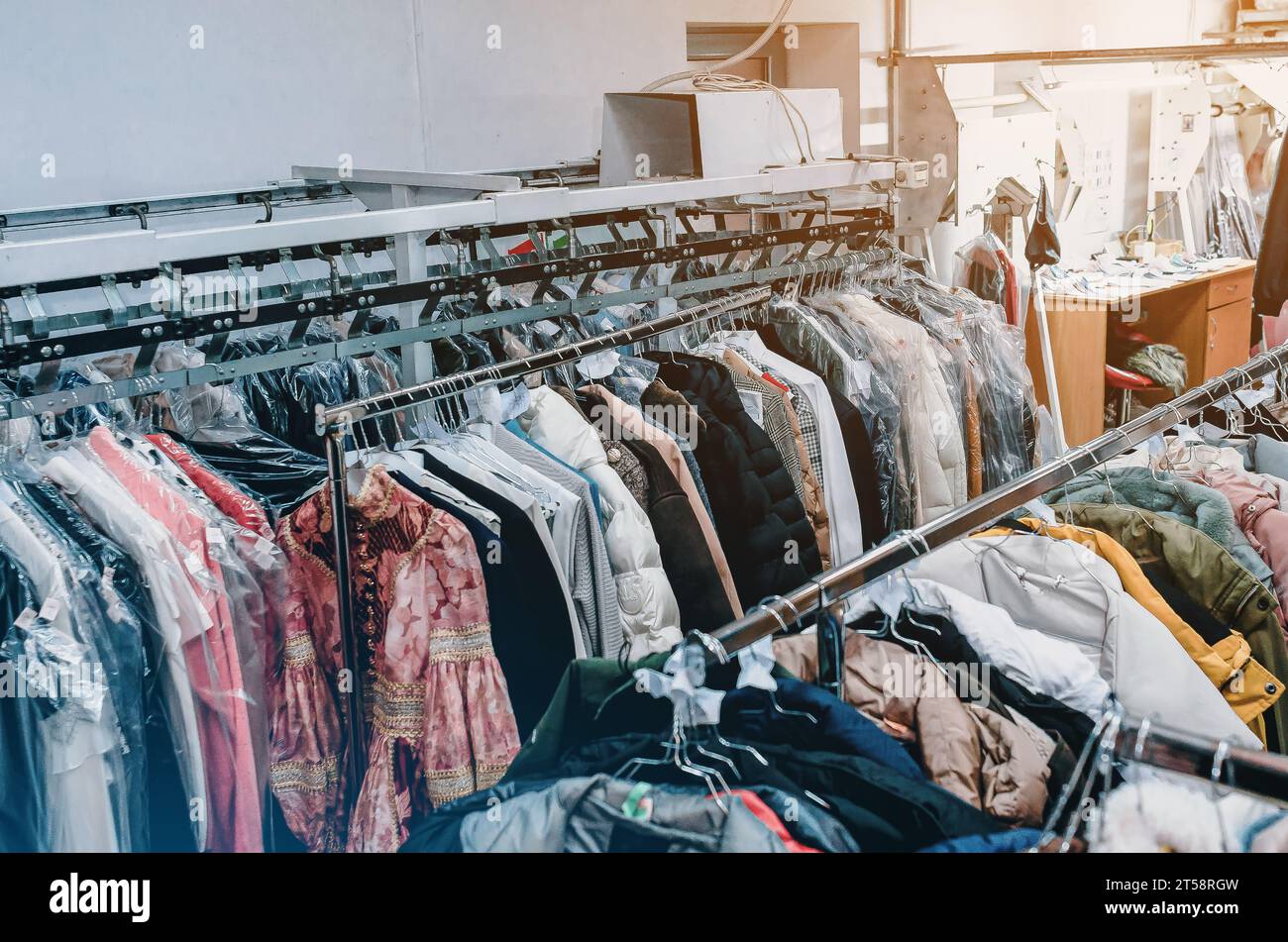 Conveyor with hangers of dry-cleaned clothes. Dry cleaning background ...