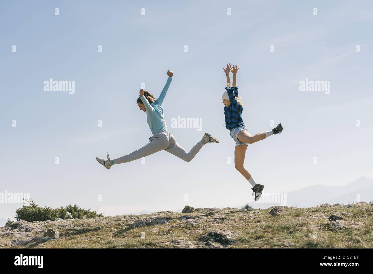 Girls jumping on top of the mountain Stock Photo - Alamy