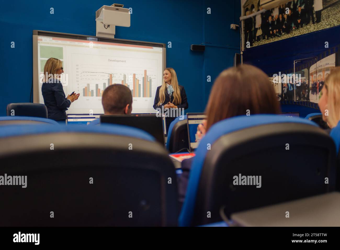 College teacher applauding to her female student after she wrote a ...