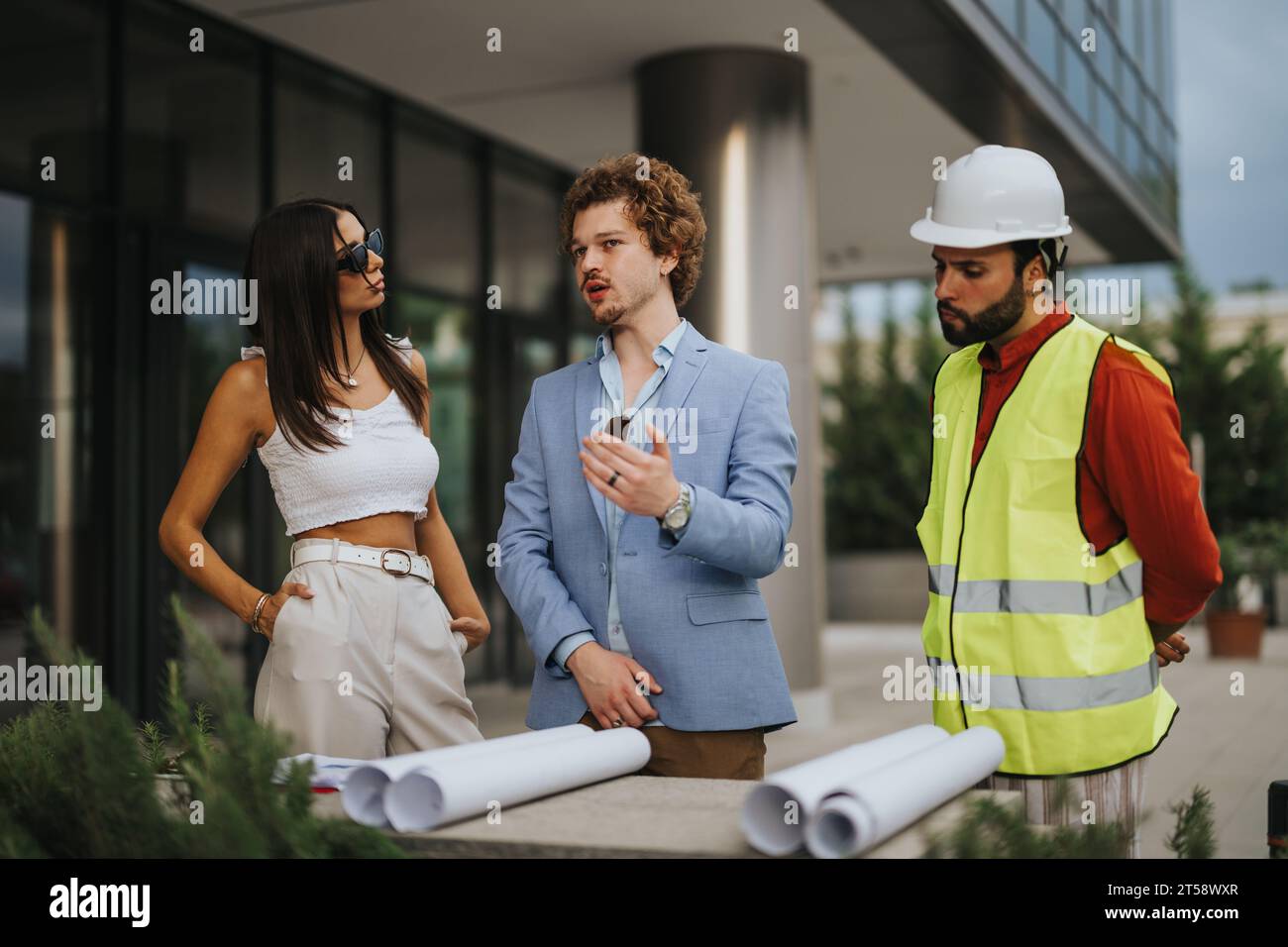 Architects and construction engineers collaborate outdoors, discussing ...
