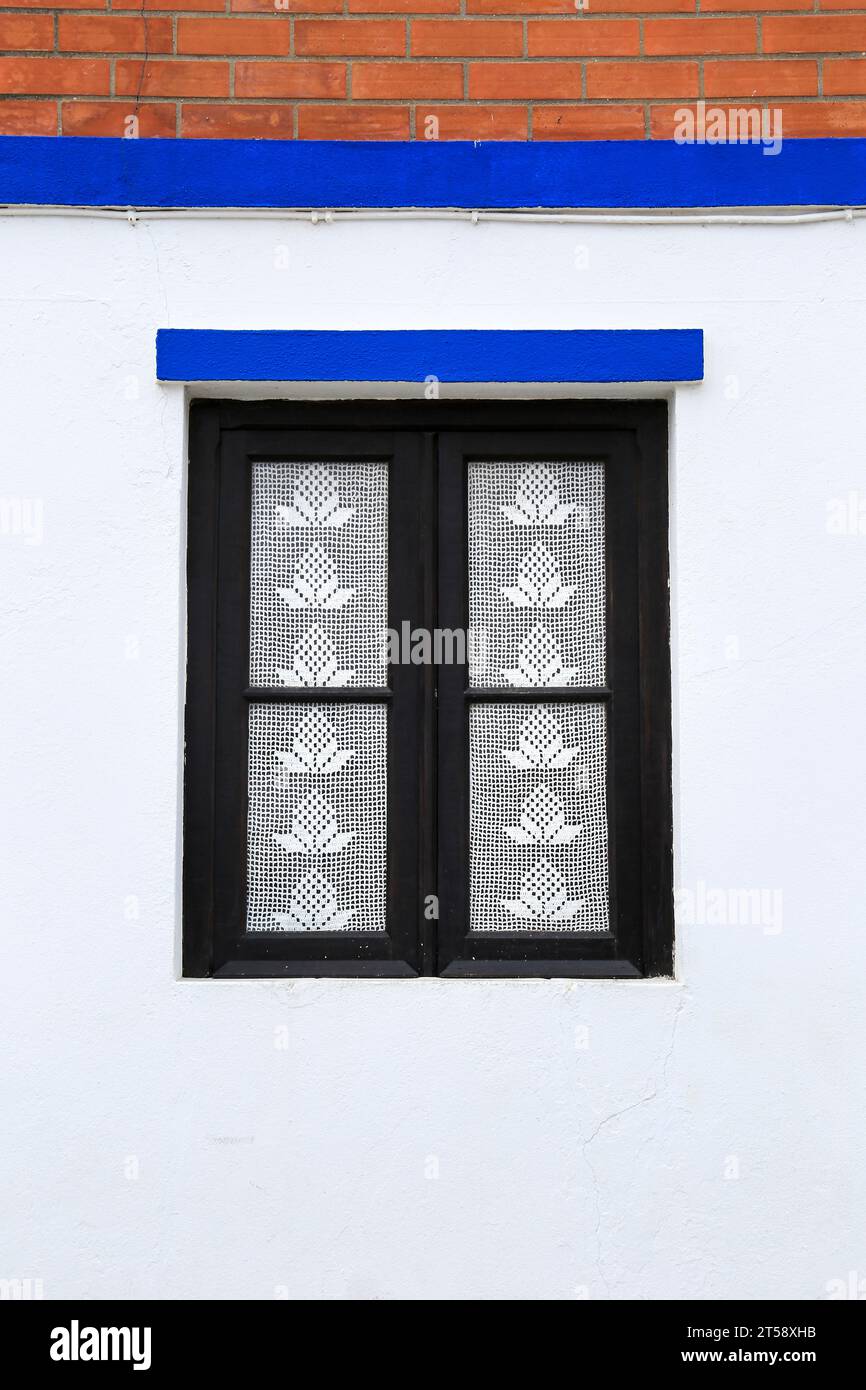 Typical Portuguese facade with black wooden window and curtain on ...