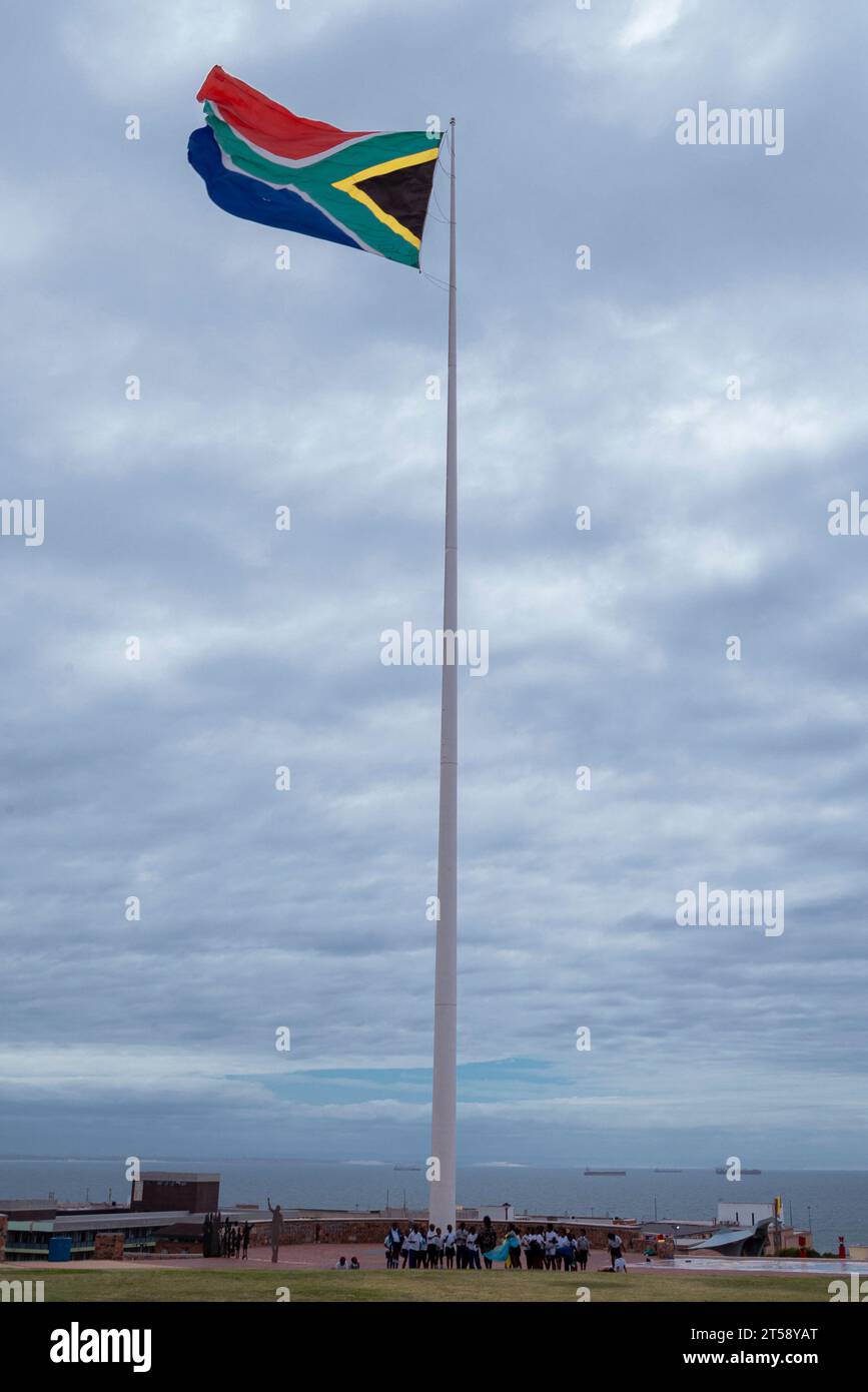 A south African flag flies in the wind on a large flagpole in Port ...