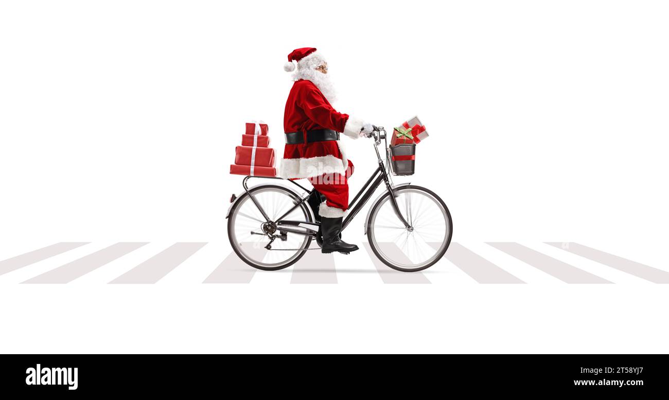 Full length profile shot of Santa Claus riding a bicycle at a pedesrian ...