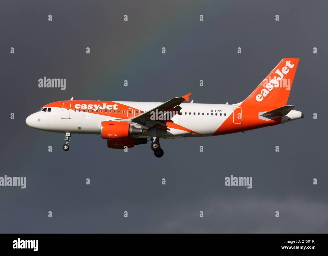 An Airbus A319 of easyjet passes in front of a rainbow whilst ...