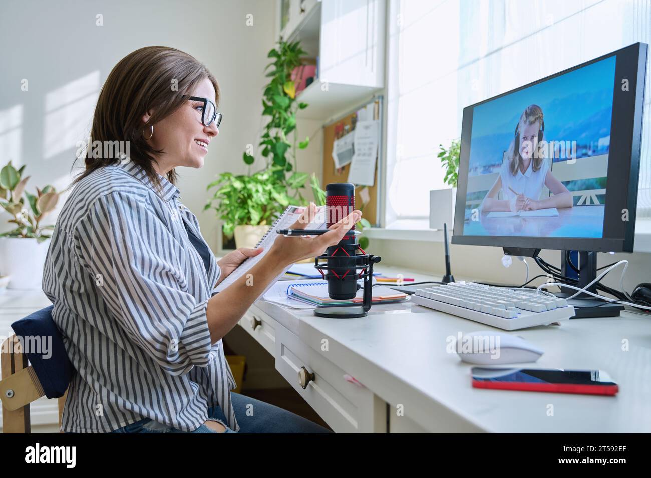 Online lesson, woman teacher teaching child girl Stock Photo - Alamy