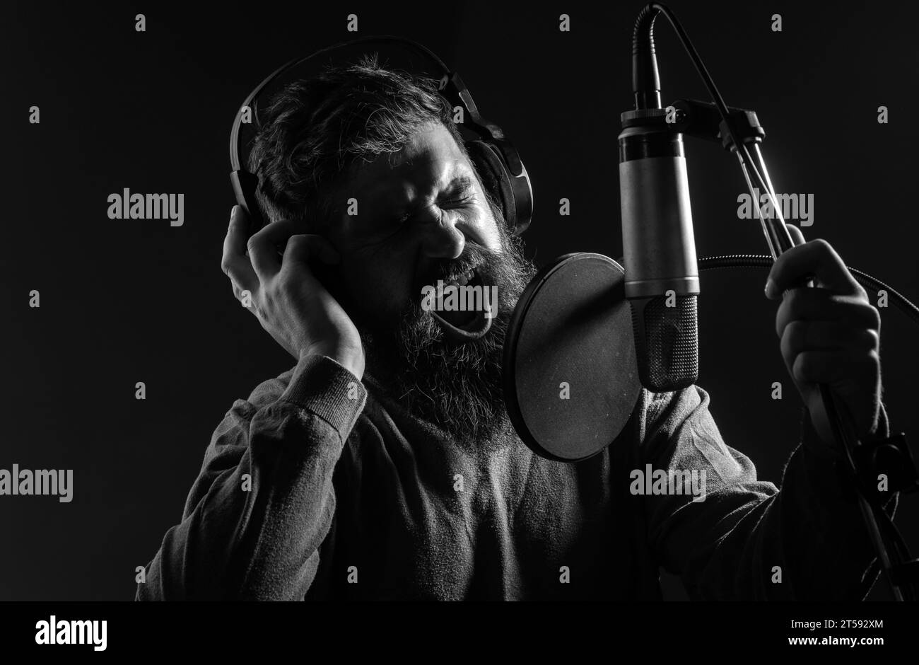 Man with microphone singing song. Musician in music hall. Funny guy ...