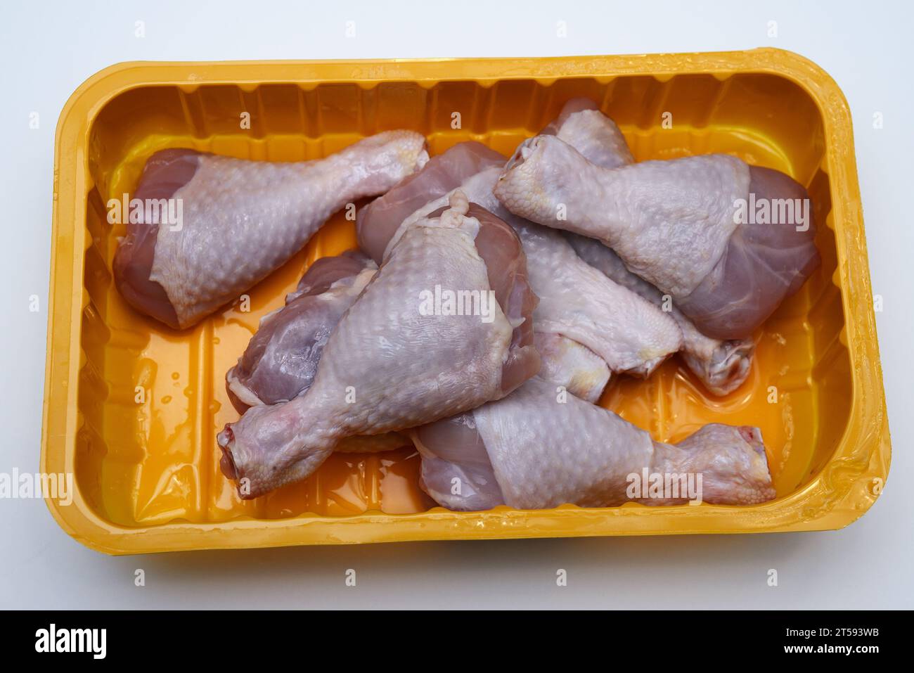 raw chicken legs in a plastic container on a white background Stock ...
