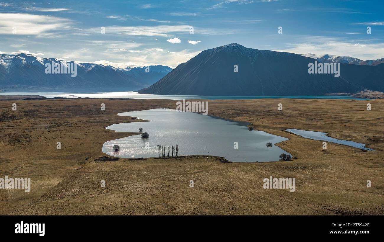 Lake Ohau road through farmland to the snow capped mountains Stock ...