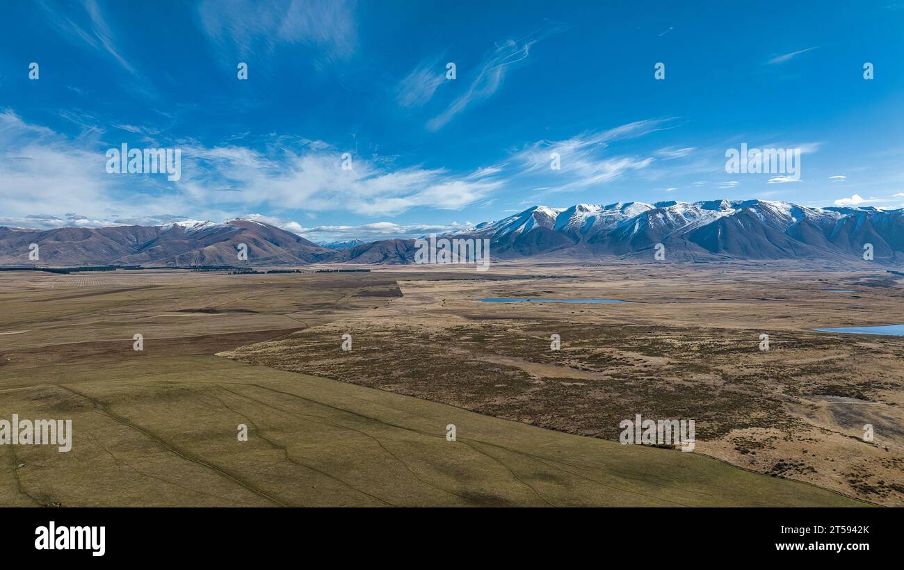 Lake Ohau road through farmland to the snow capped mountains Stock ...