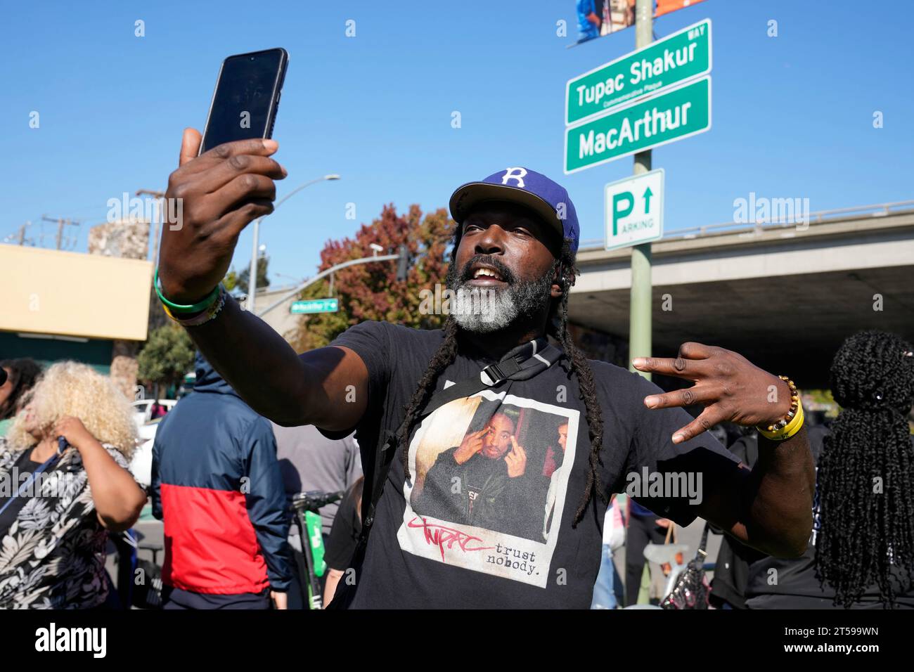 Randy Moore, of Los Angeles, poses beneath a new sign during a street ...