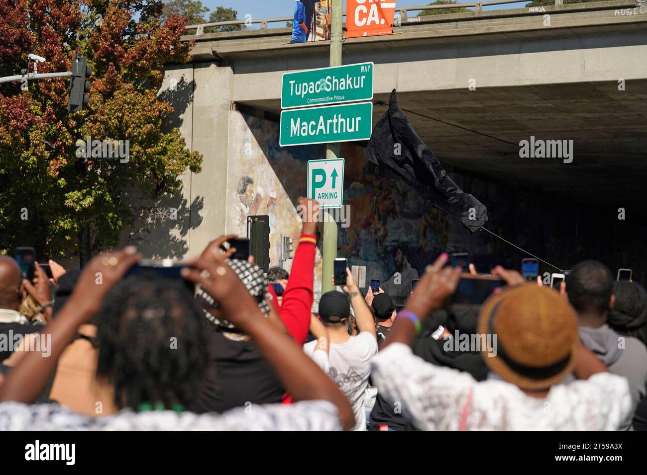 People watch as a new sign is unveiled during a street renaming ...
