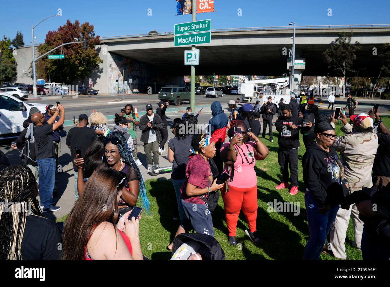 People take pictures and gather beneath a new sign during a street ...