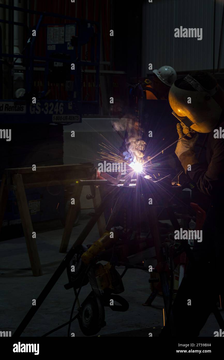 Worker welding piping used in a cold-storage (industrial refrigeration ...