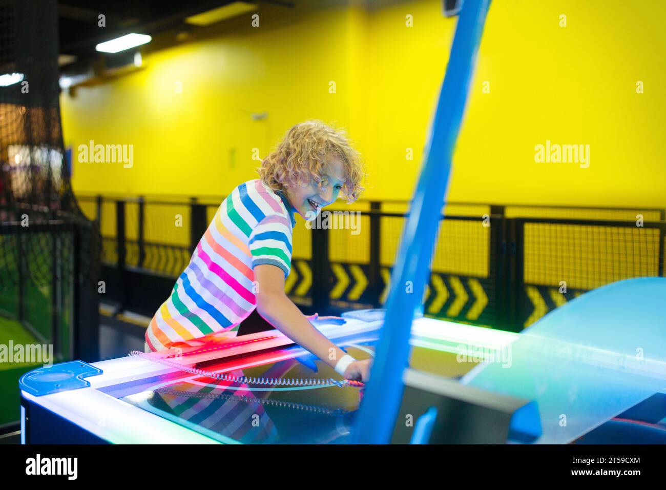 Kids play air hockey. Fun arcade games. Child at amusement park. Family ...